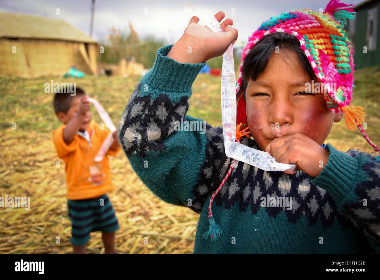 Portrait of Peruvian Uros tribe kids playing on island on lake Titicaca ...