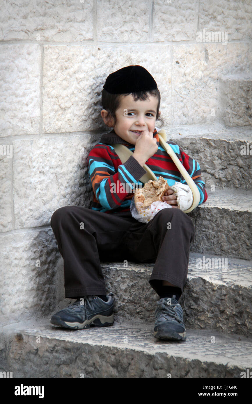 Jewish smiling kid with traditional kippa and plastered arm in ...