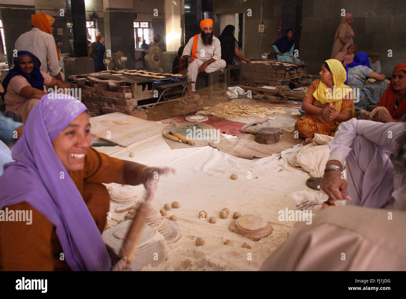 Volunteers working in the kitchen of the Golden temple, Amritsar ...
