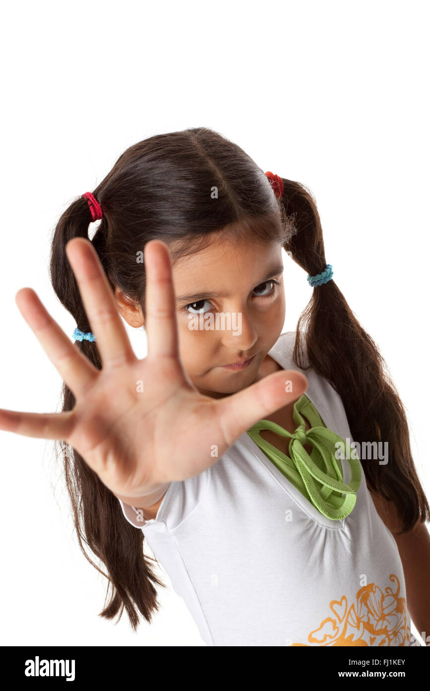 Little girl is makes a stop gesture with her hand on white background ...
