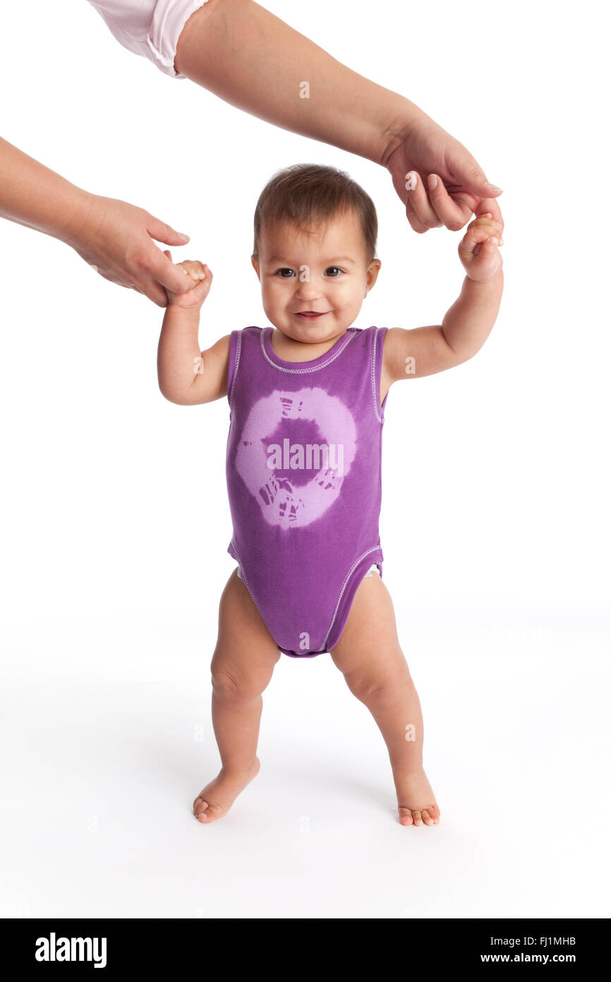 Proud baby girl standing with some help on white background Stock Photo ...