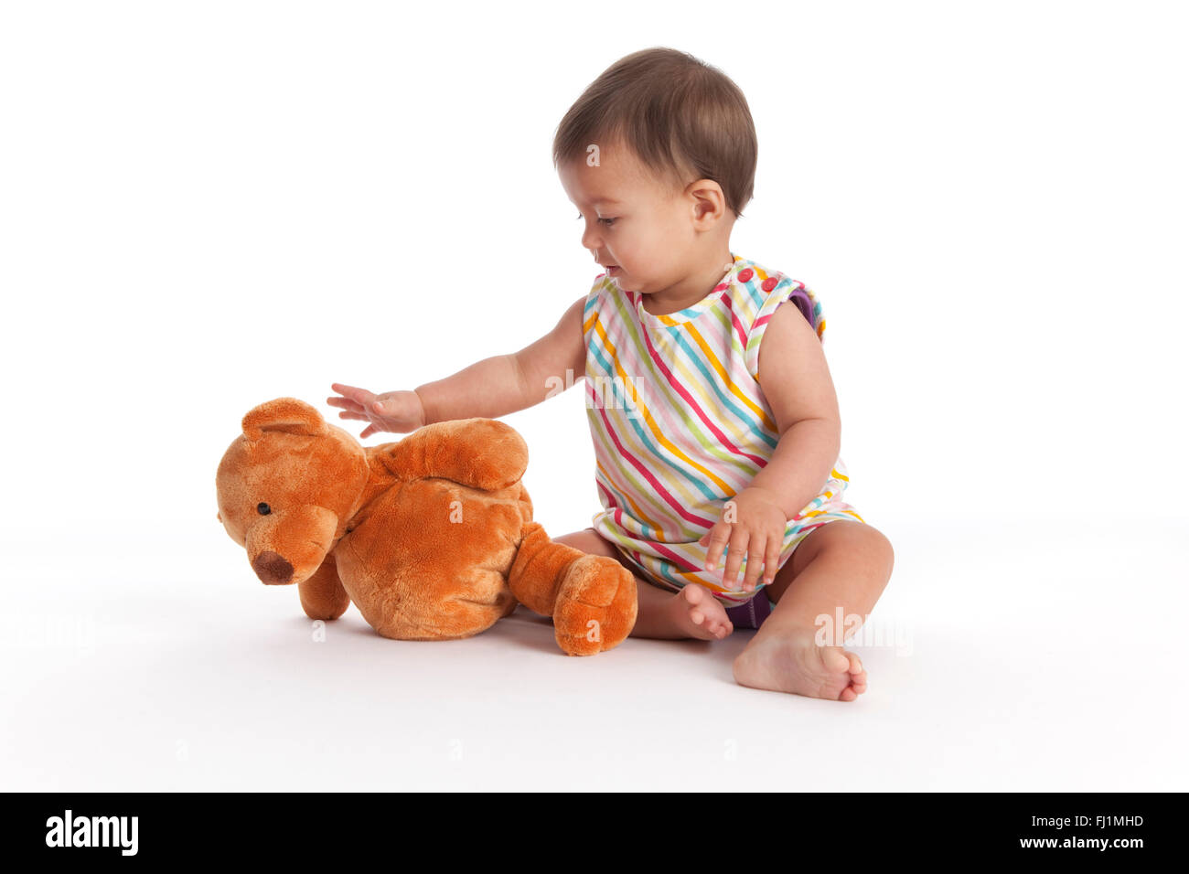 Baby girl reaching for her toy bear on white background Stock Photo - Alamy