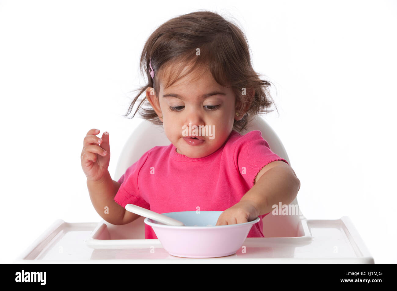 Baby girl is eating with her hand on white background Stock Photo - Alamy