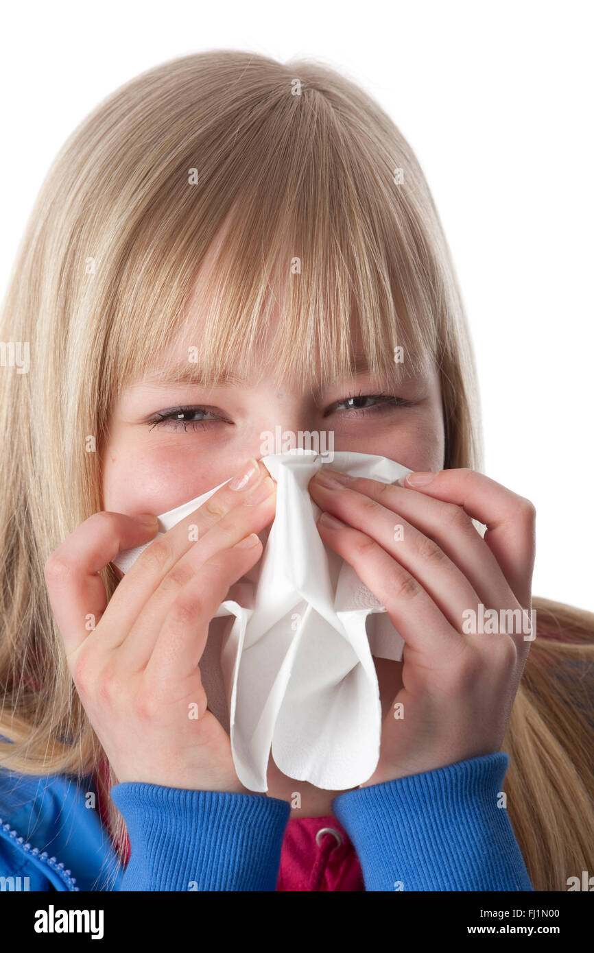 Portrait of a teenage girl sneezing in a handcherchief at white ...