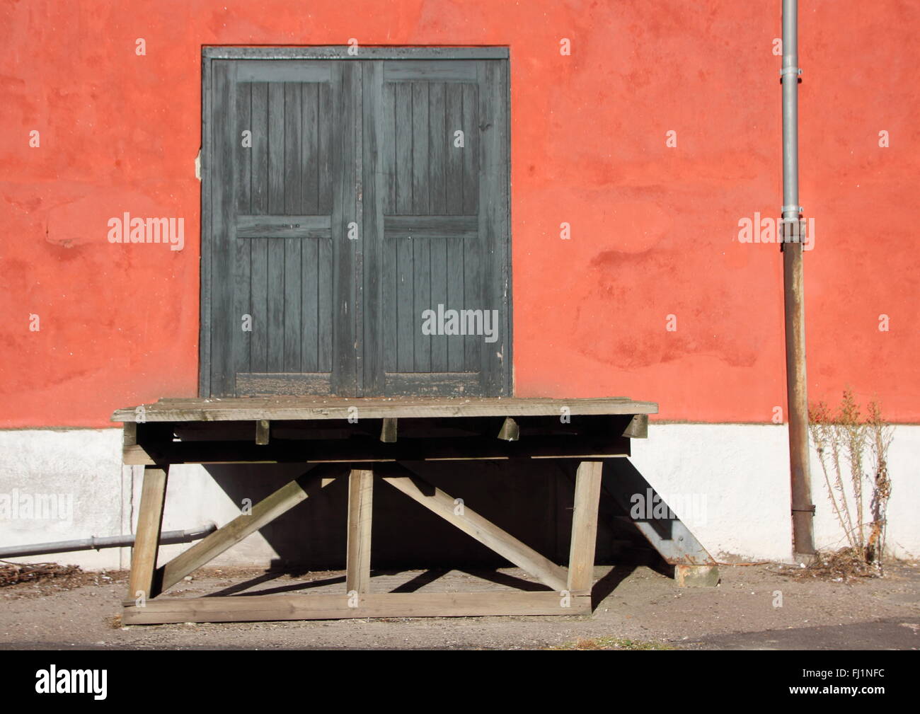 Old Wooden Cargo Ramp with Shadow and Red Wall Stock Photo - Alamy