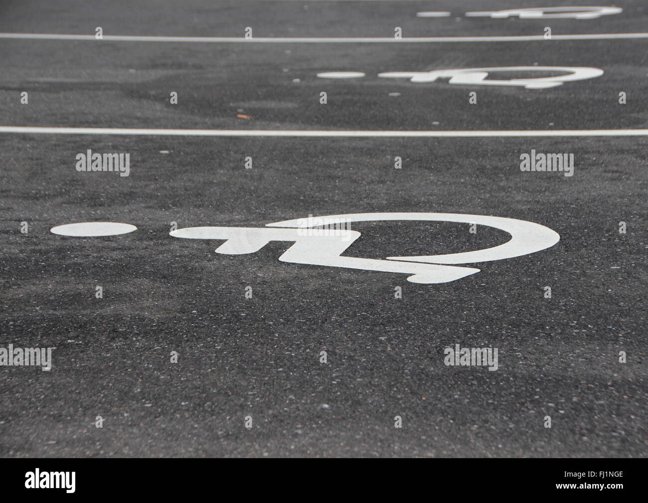 Line of White Handicap Disabled Sign on Black Asphalt Stock Photo - Alamy