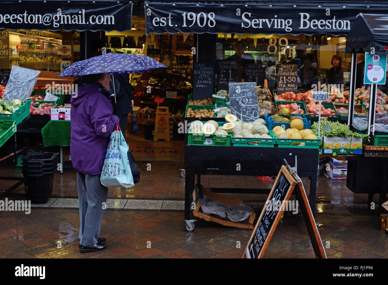 Lady shopping in the rain Stock Photo - Alamy