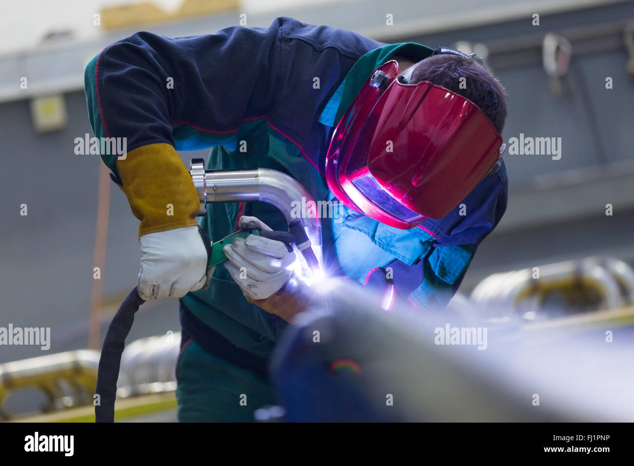 Industrial worker welding in metal factory Stock Photo - Alamy