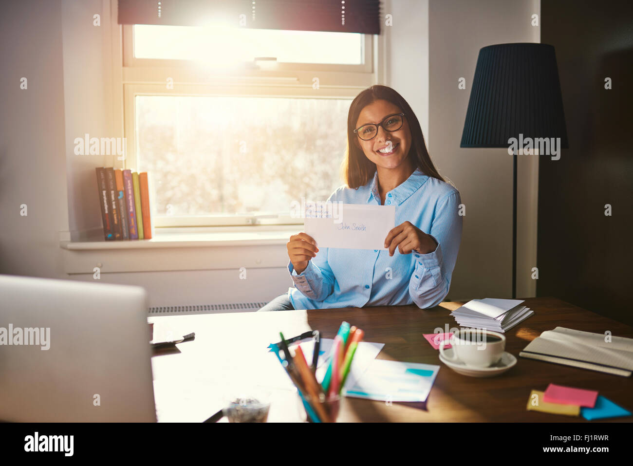 Business woman holding a letter to send while smiling at camera Stock ...