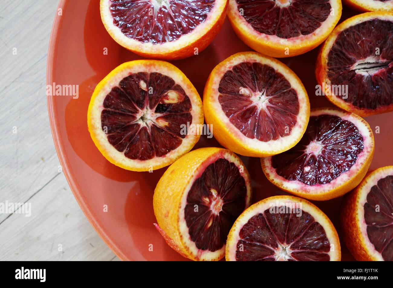 Plate of colorful blood oranges cut in half Stock Photo - Alamy
