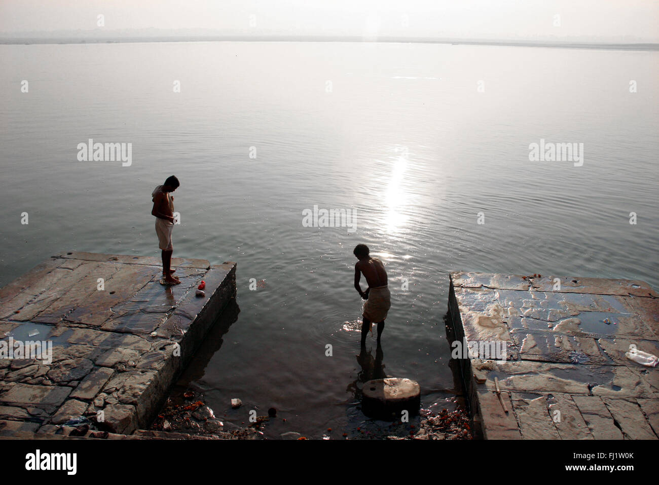 Two men are bathing on a ghat along the Holy Ganges in Varanasi, India ...