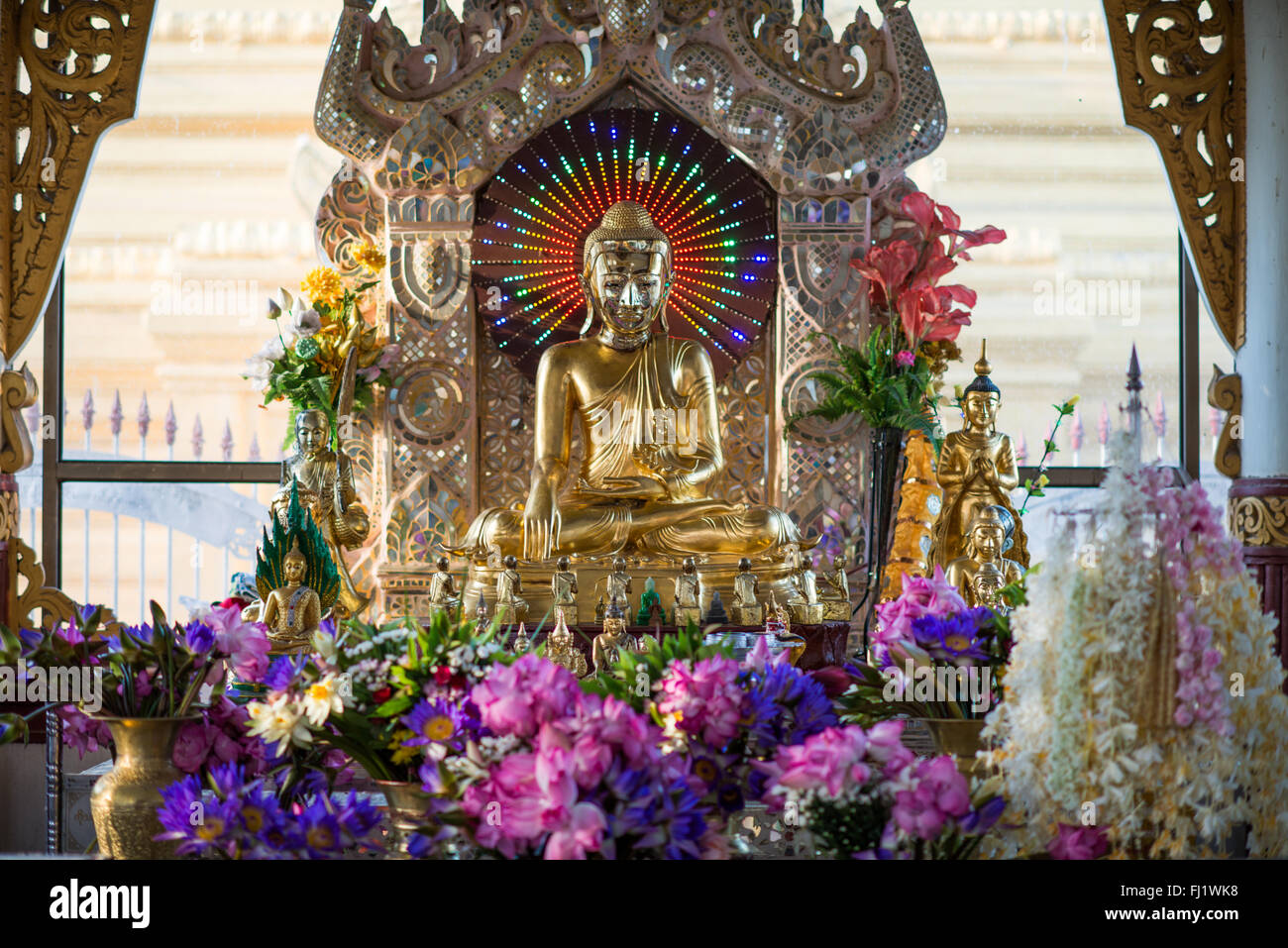 MANDALAY, Myanmar — A seated Buddha statue and small shrine within the ...