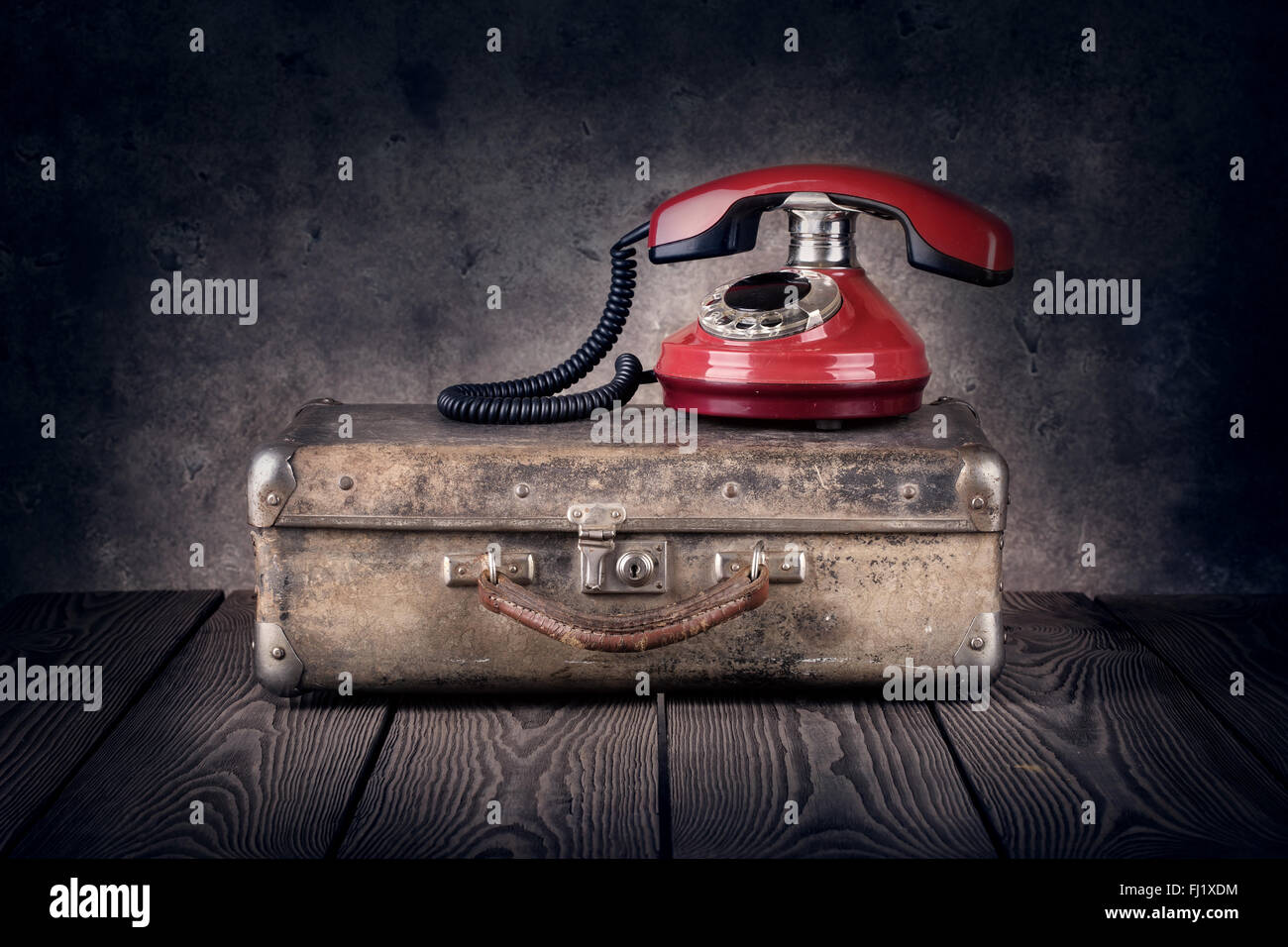 Old suitcase with the phone on wooden floor with dark background Stock ...