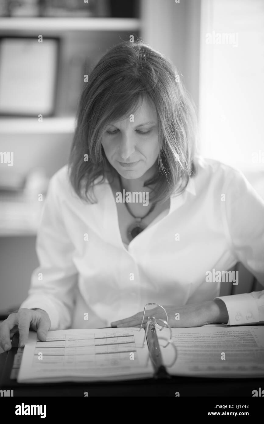 Woman reading at her office desk Stock Photo - Alamy