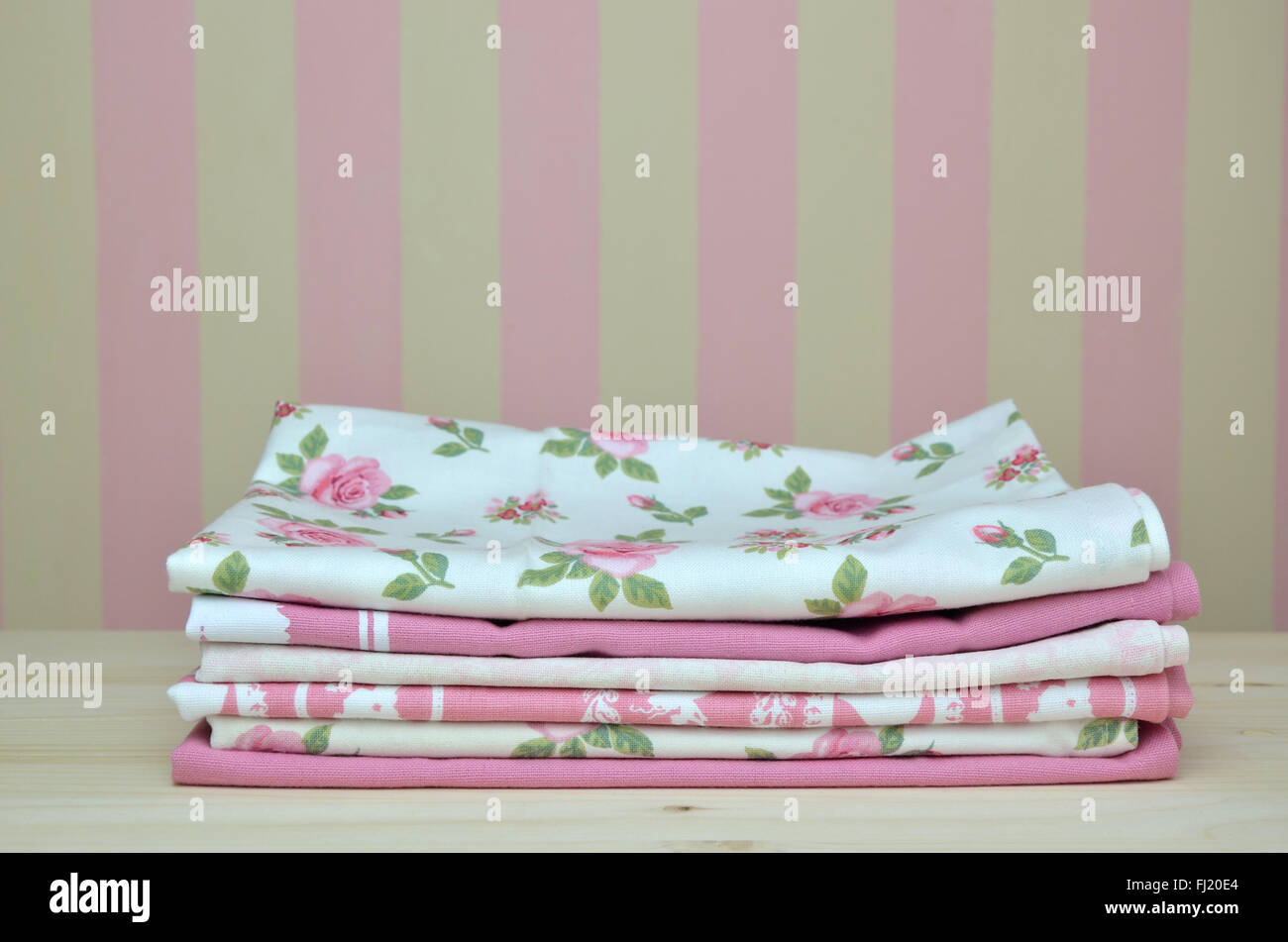 Pile of pink kitchen towels with romantic patterns on kitchen desk ...