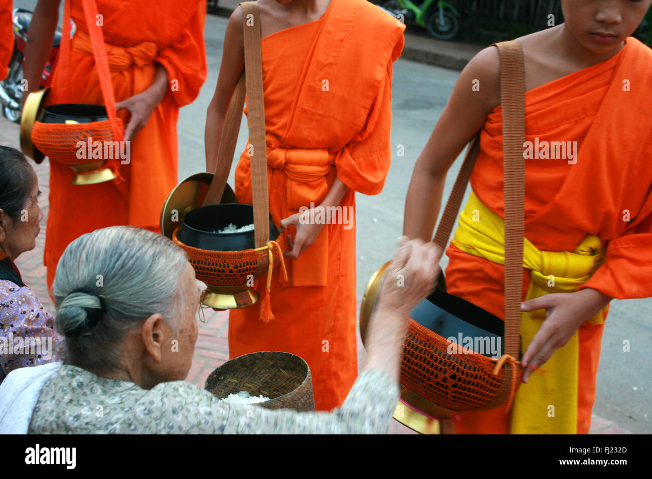 Tak bat ritual - Buddhist monks receive rice and food from pupulation ...