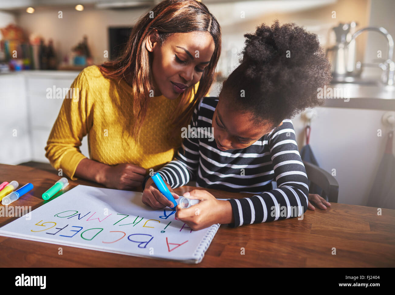 Little girl learning the alphabet using colored letters Stock Photo - Alamy