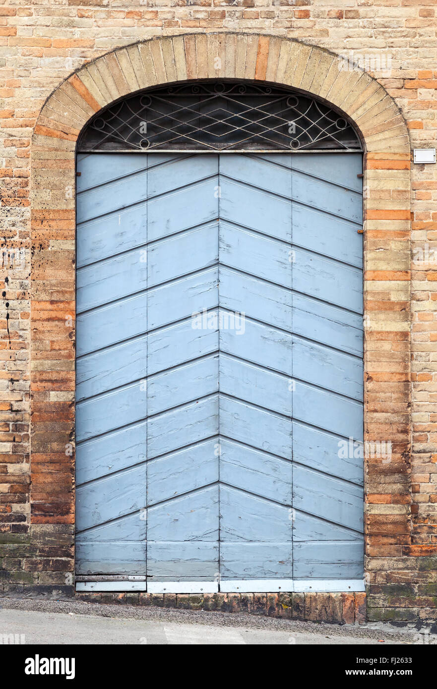 Blue wooden door with arch in old stone wall, background photo texture ...