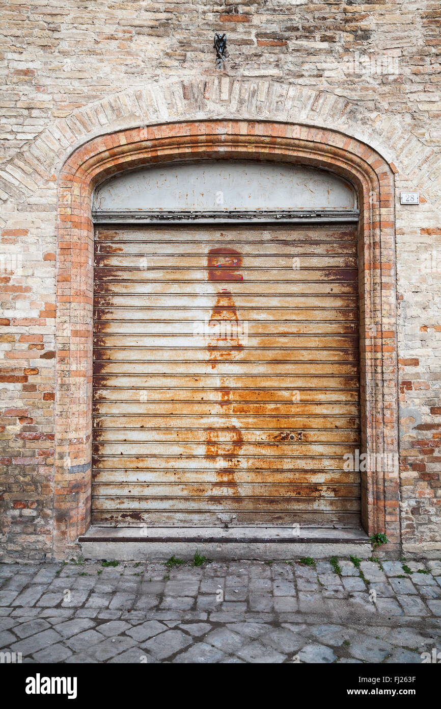 Gray rusted metal gate in old brick wall, background photo texture ...