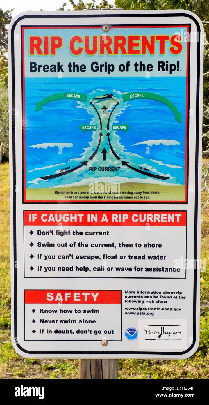A sign warns beachgoers of dangerous rip currents that might develop in ...