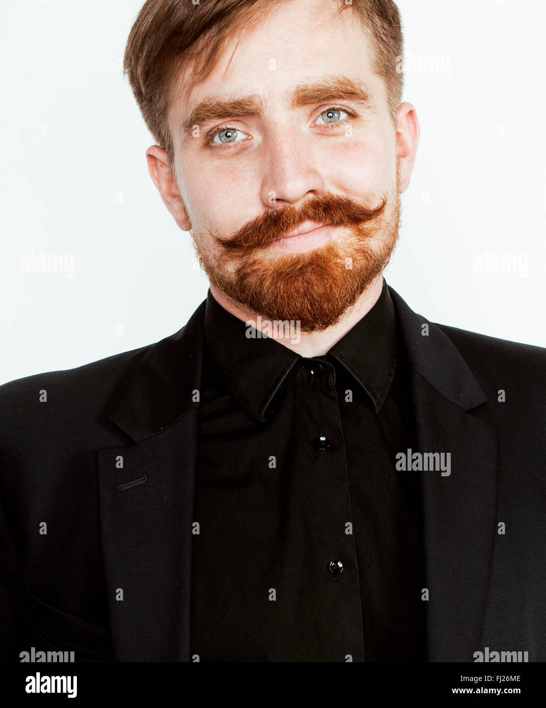 young red hair man with beard and mustache in black suit on white ...