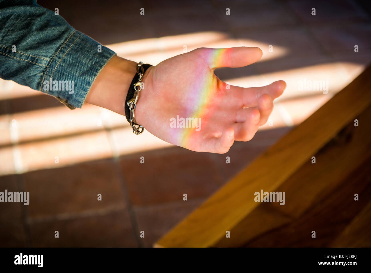 Young man showing rainbow reflection on his hand Stock Photo - Alamy