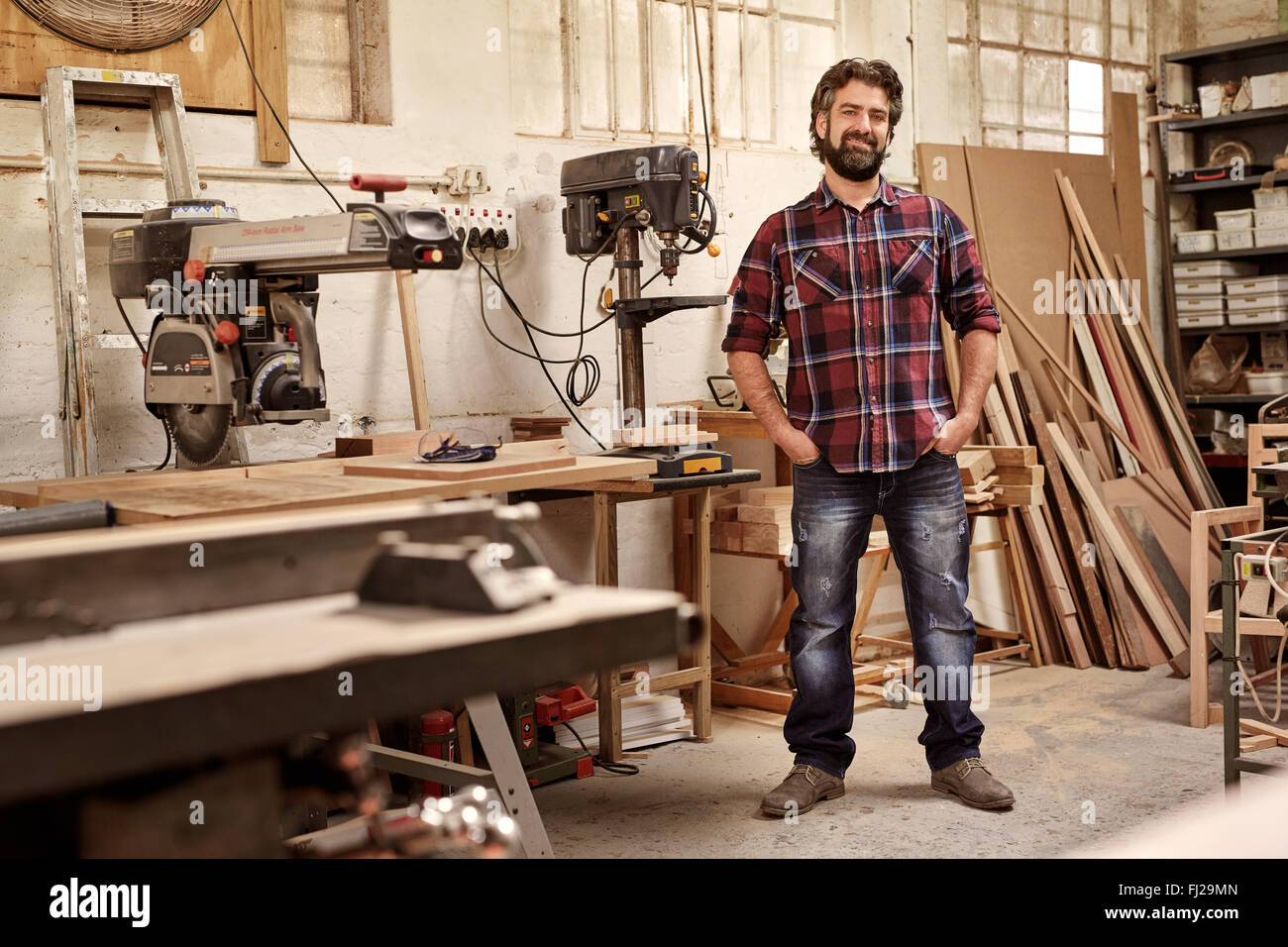 Carpentry business owner standing in his workshop with machinery Stock ...