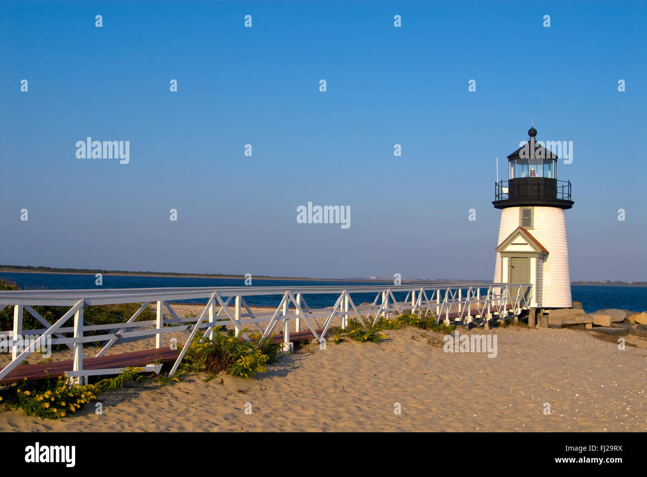 Wooden walkway leads to Brant Point lighthouse tower, a famous iconic ...