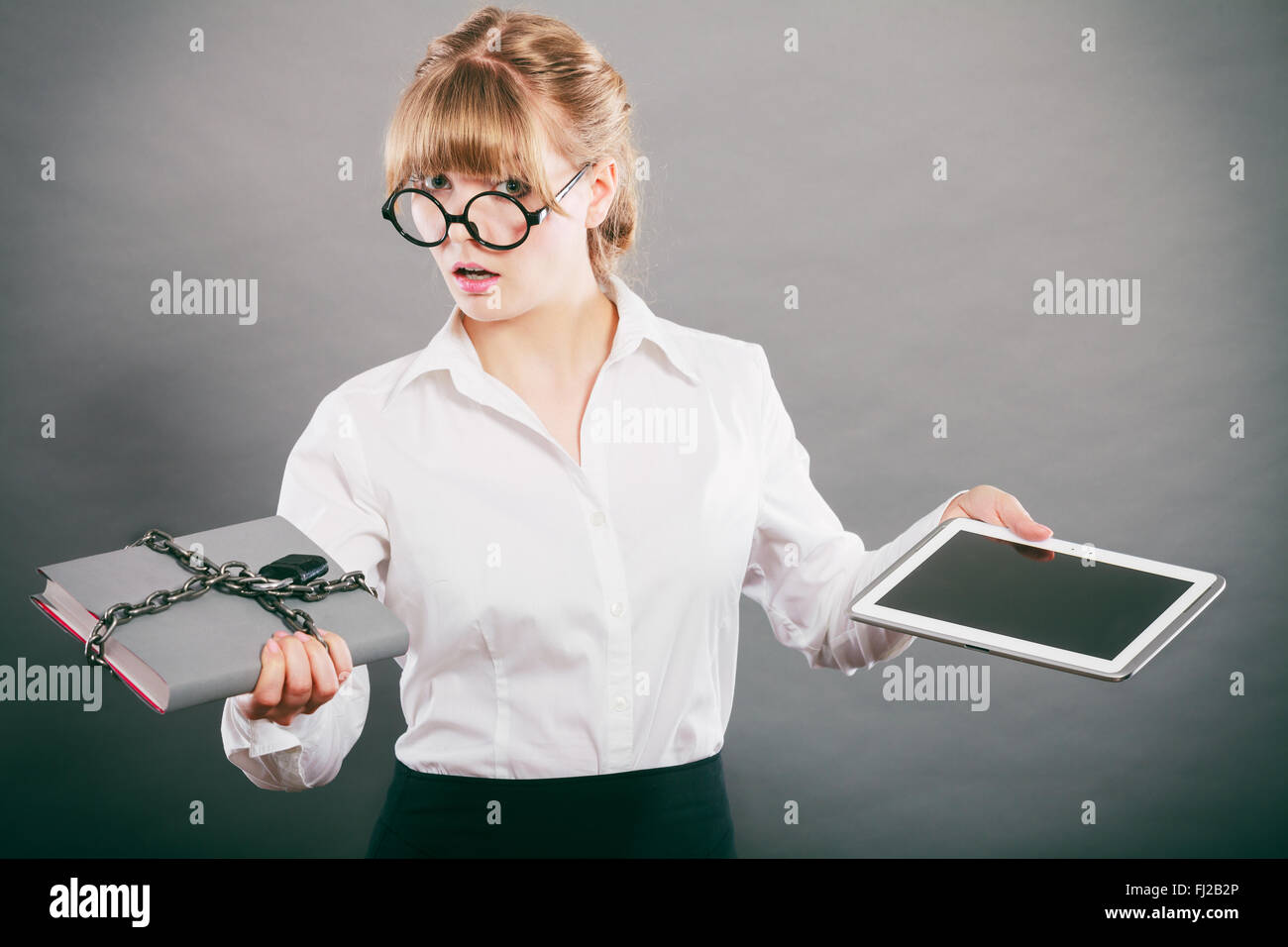 Businesswoman holding document and tablet. Choice between digital and ...
