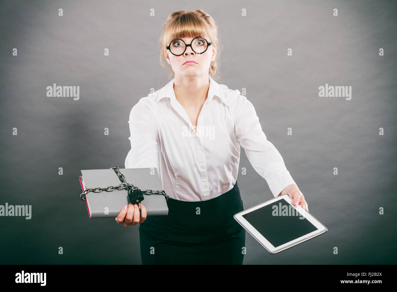 Businesswoman holding document and tablet. Choice between digital and ...