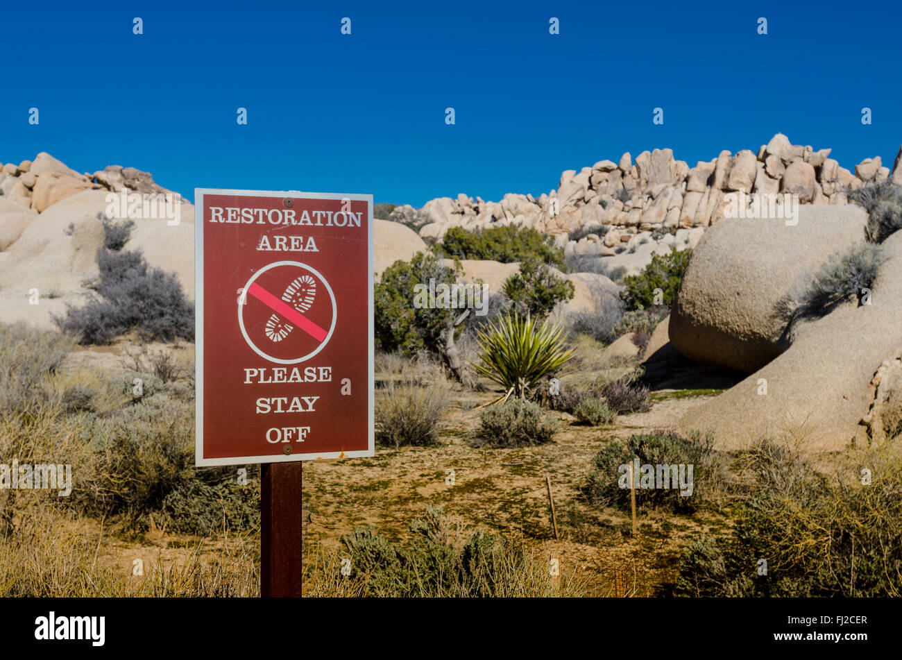 Restoration area sign with desert rocks reminders visitors of fragile ...