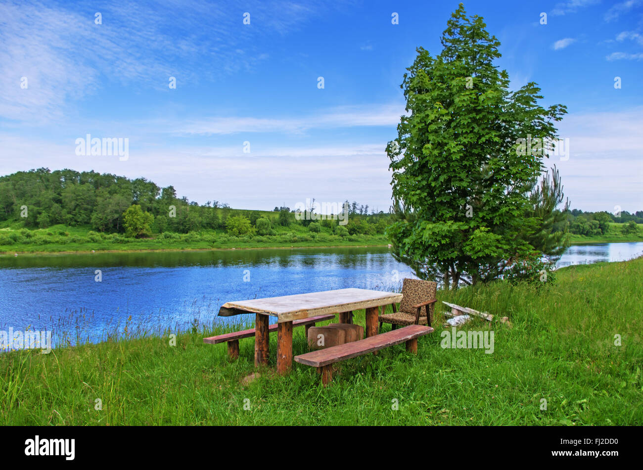 Village landscape. Table and benches by the river Stock Photo - Alamy