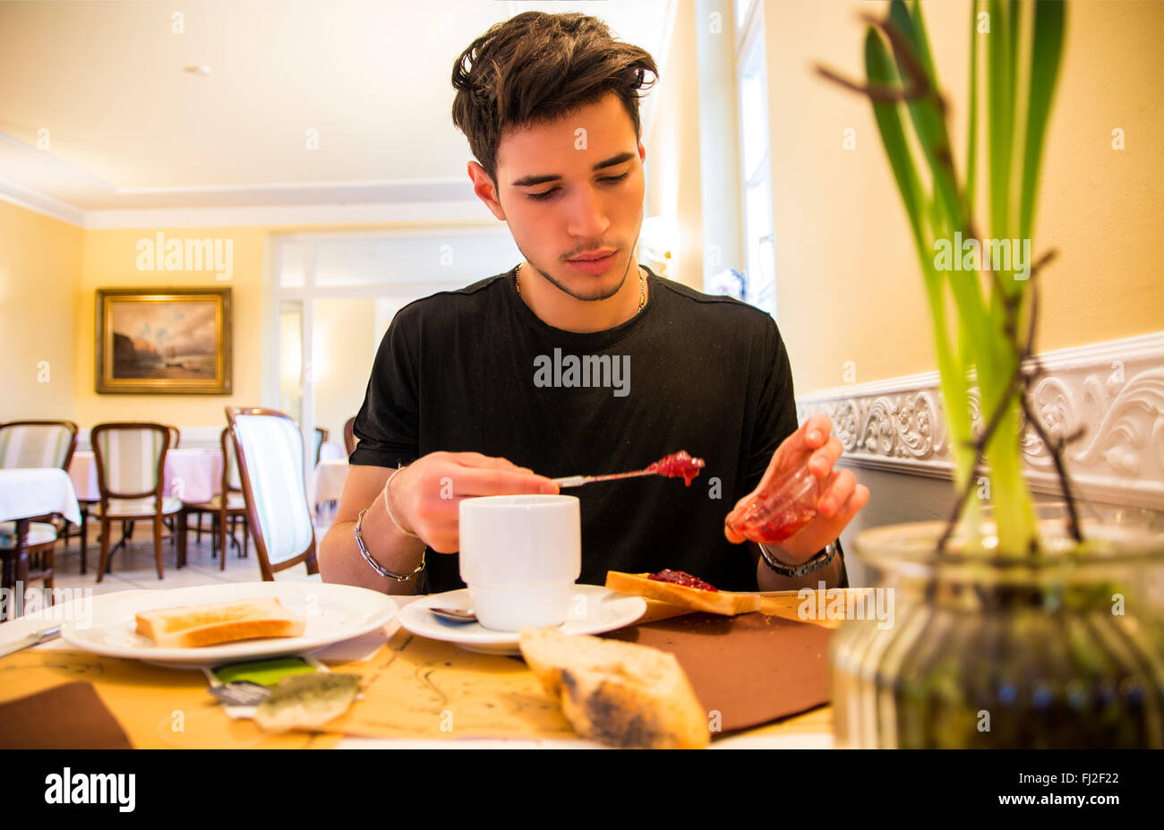 Attractive Young Man Eating Breakfast, Having a Slice of Bread with Jam ...