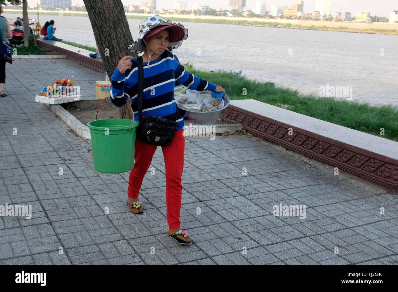 Woman carrying food along the riverbank in Phnom Penh, Cambodia Stock ...