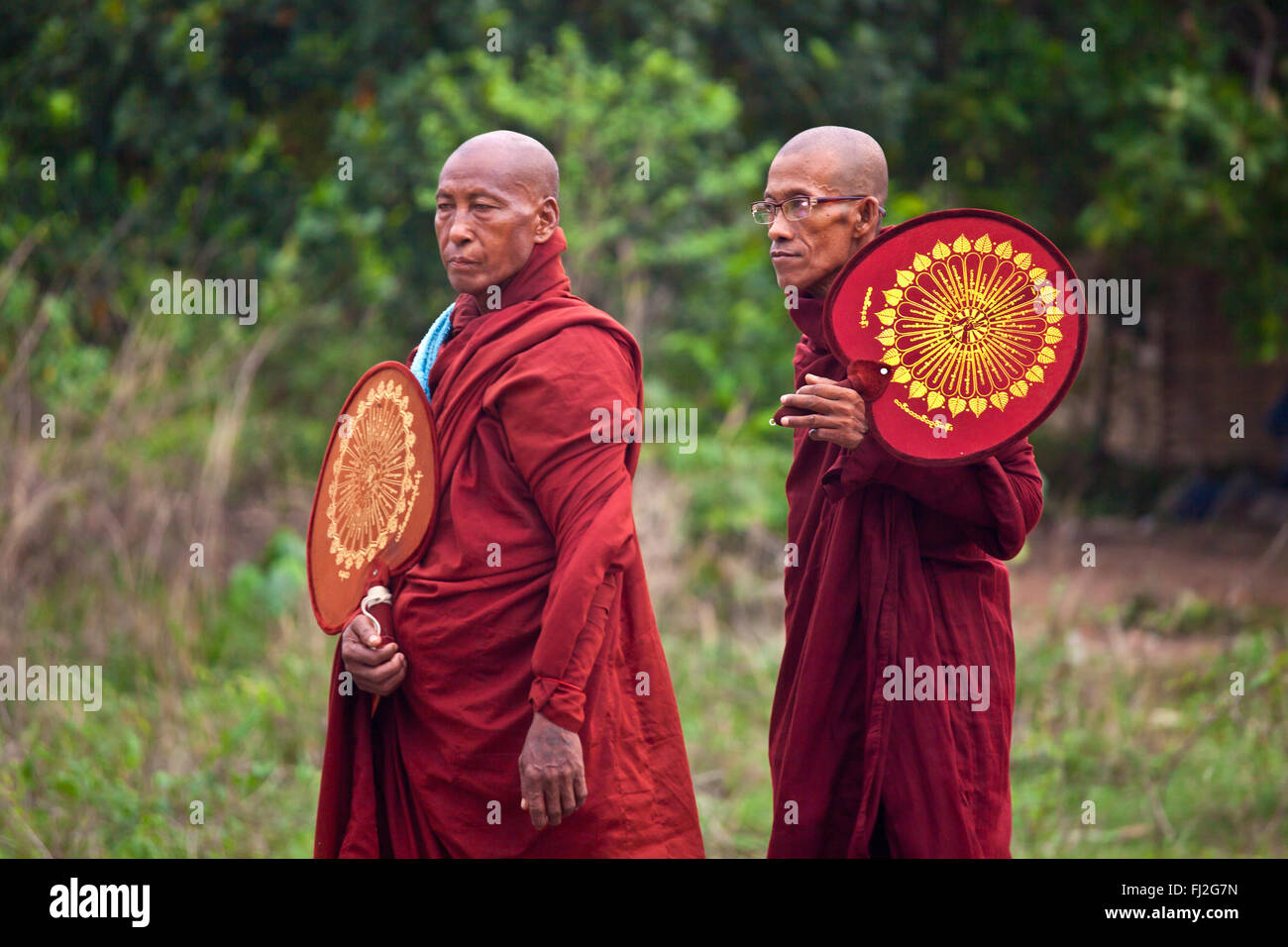 Buddhist monks with fans walk along the road bago hi-res stock ...