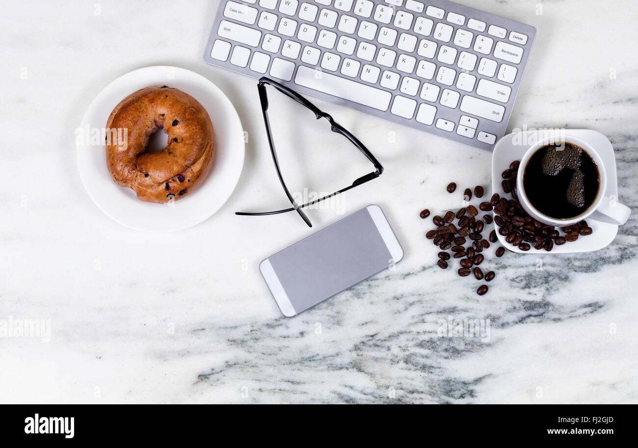 Overhead view marble kitchen counter top with computer keyboard, cell ...