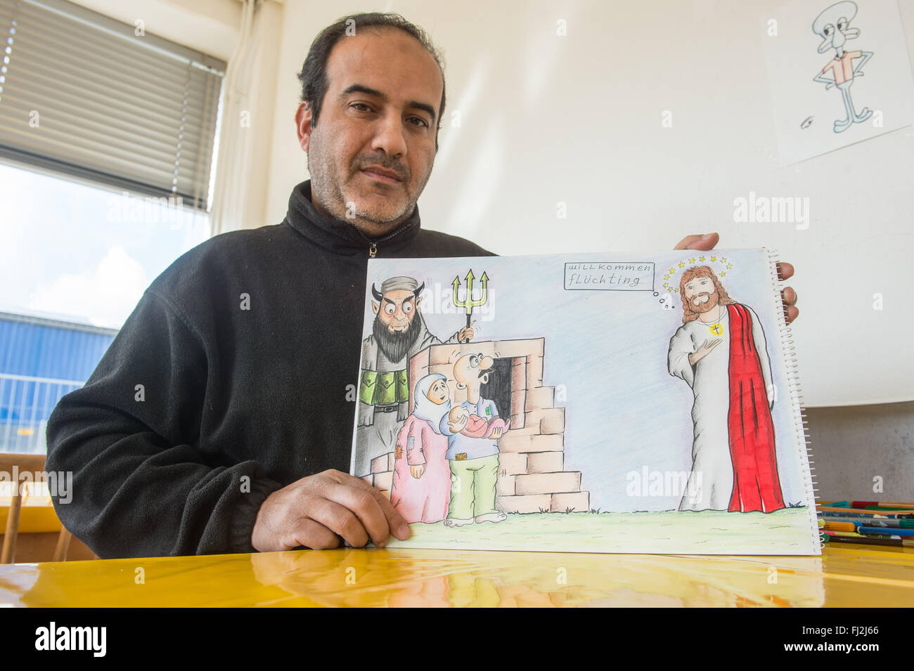 Viechtach, Germany. 26th Feb, 2016. Syrian cartoonist Ali Abdo shows his drawing of a Muslim ...