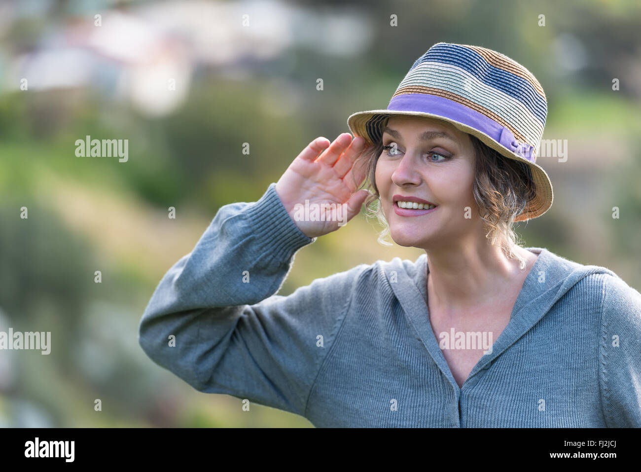 Woman in hat listening the sounds in nature Stock Photo - Alamy