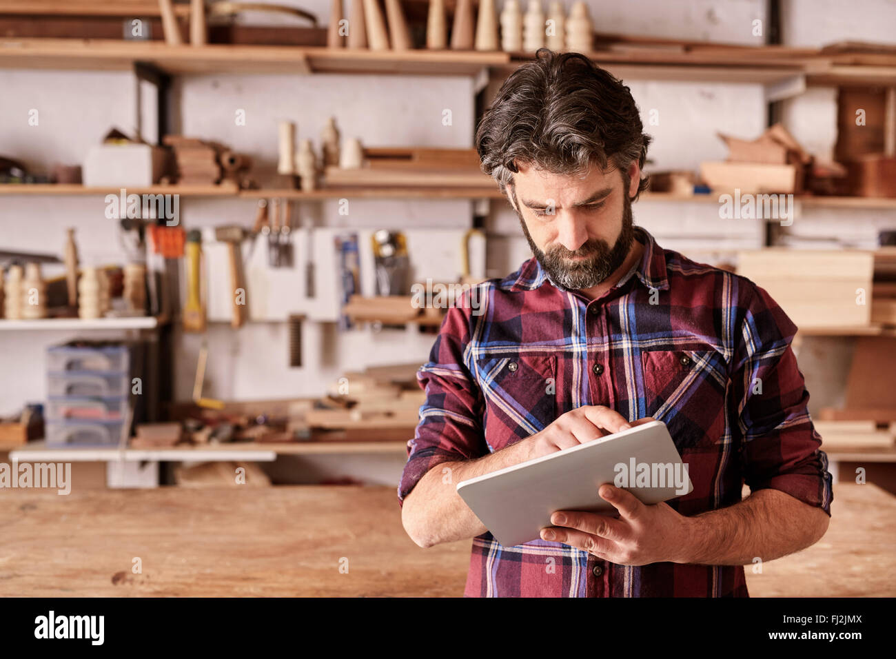 Woodwork designer using a digital tablet in his studio Stock Photo - Alamy