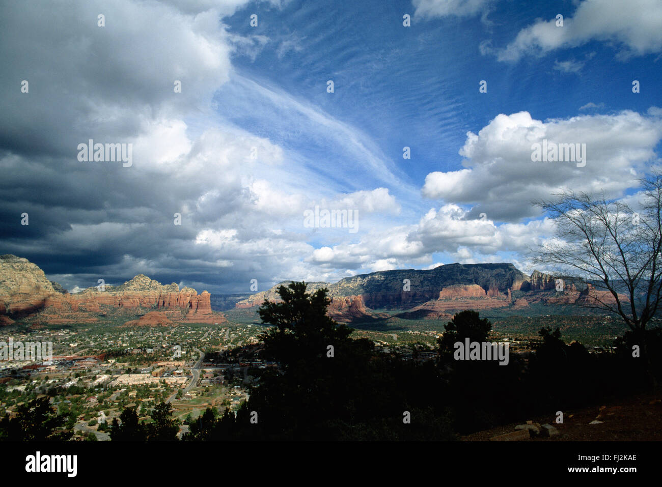 CLOUDS and RED ROCK formations of Coconino National Forest tower over ...