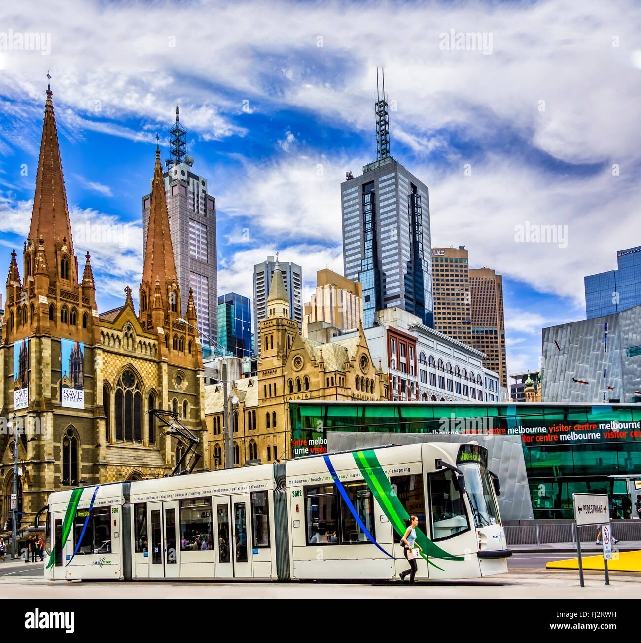 Woman jogging past a modern white Melbourne tram and tourist info ...