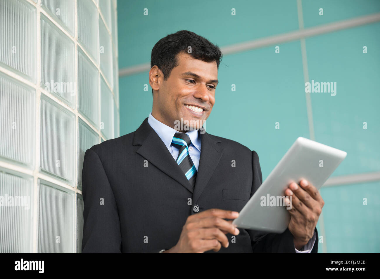 Happy Indian business man using his digital Tablet device Stock Photo ...