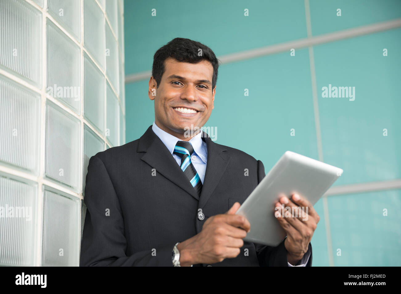 Happy Indian business man using his digital Tablet device Stock Photo ...