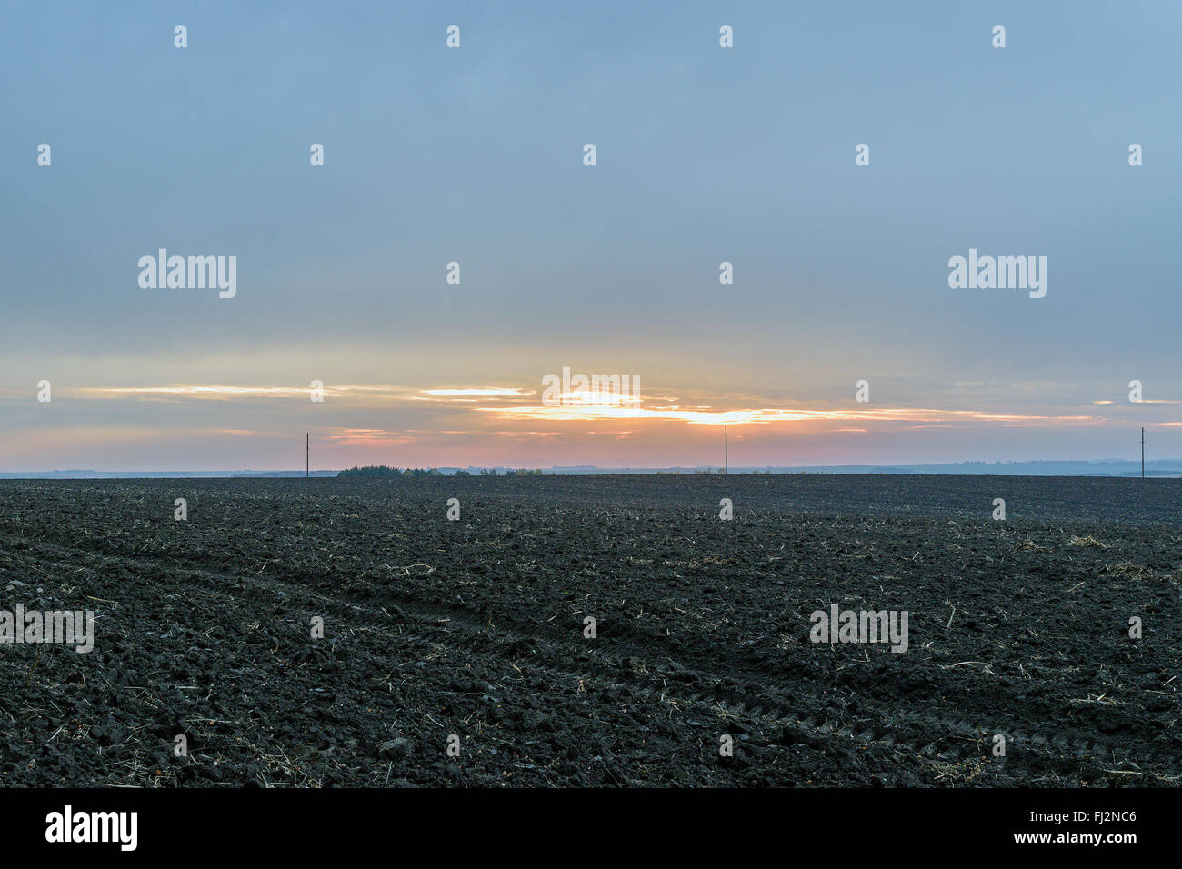 Evening sunset on the horizon behind the plowed field Stock Photo - Alamy