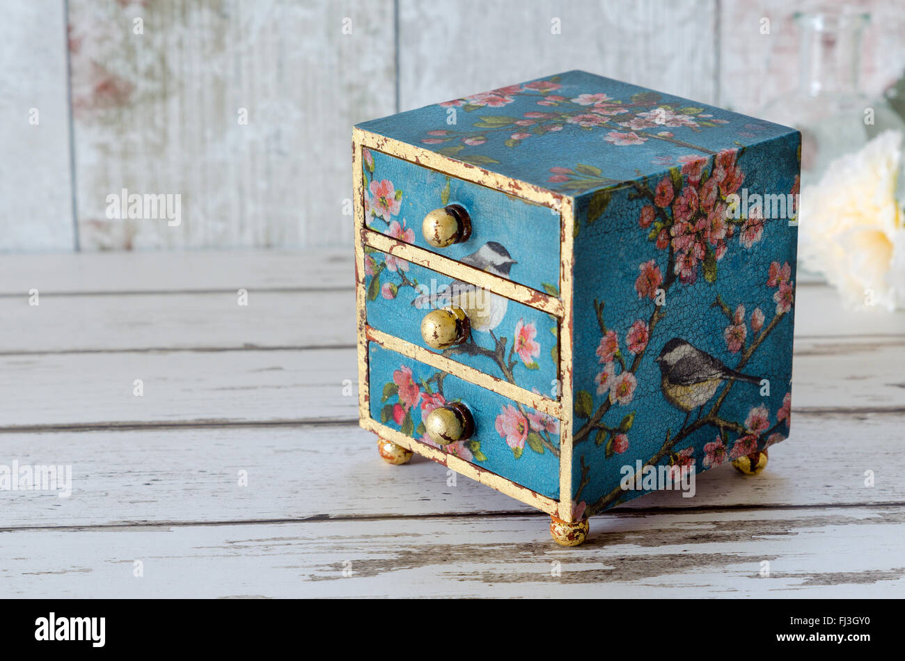 A handmade mini chest of three drawers decoupaged with blue floral ...