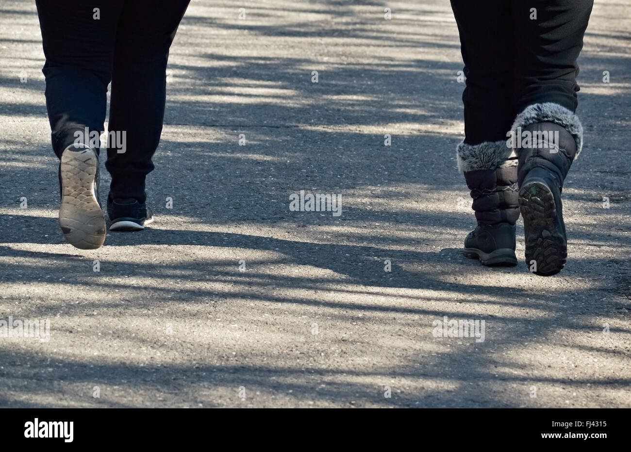 Closeup of the feet of two people walking in the park Stock Photo - Alamy