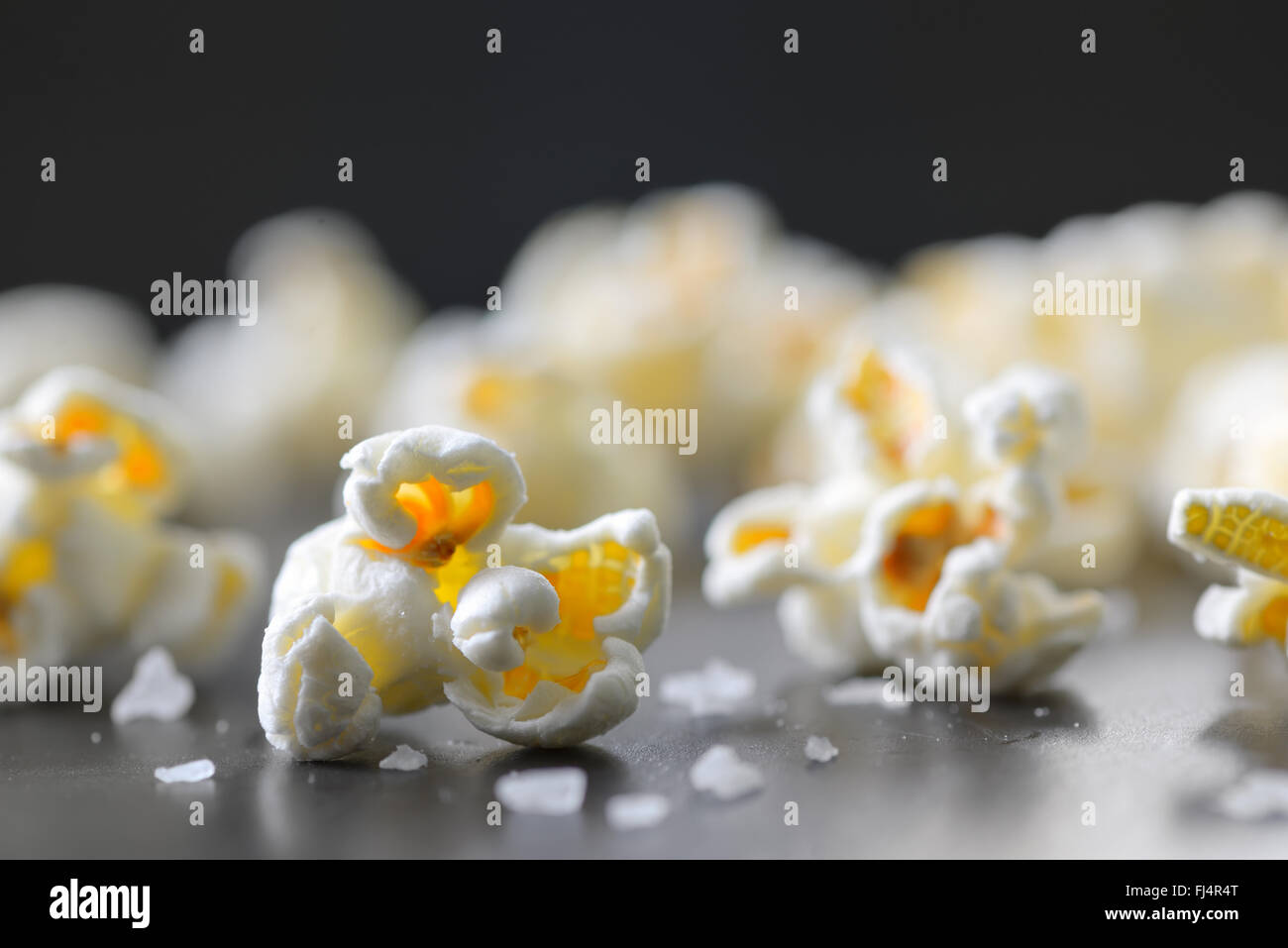 Popcorn and salt isolated on black background Stock Photo - Alamy