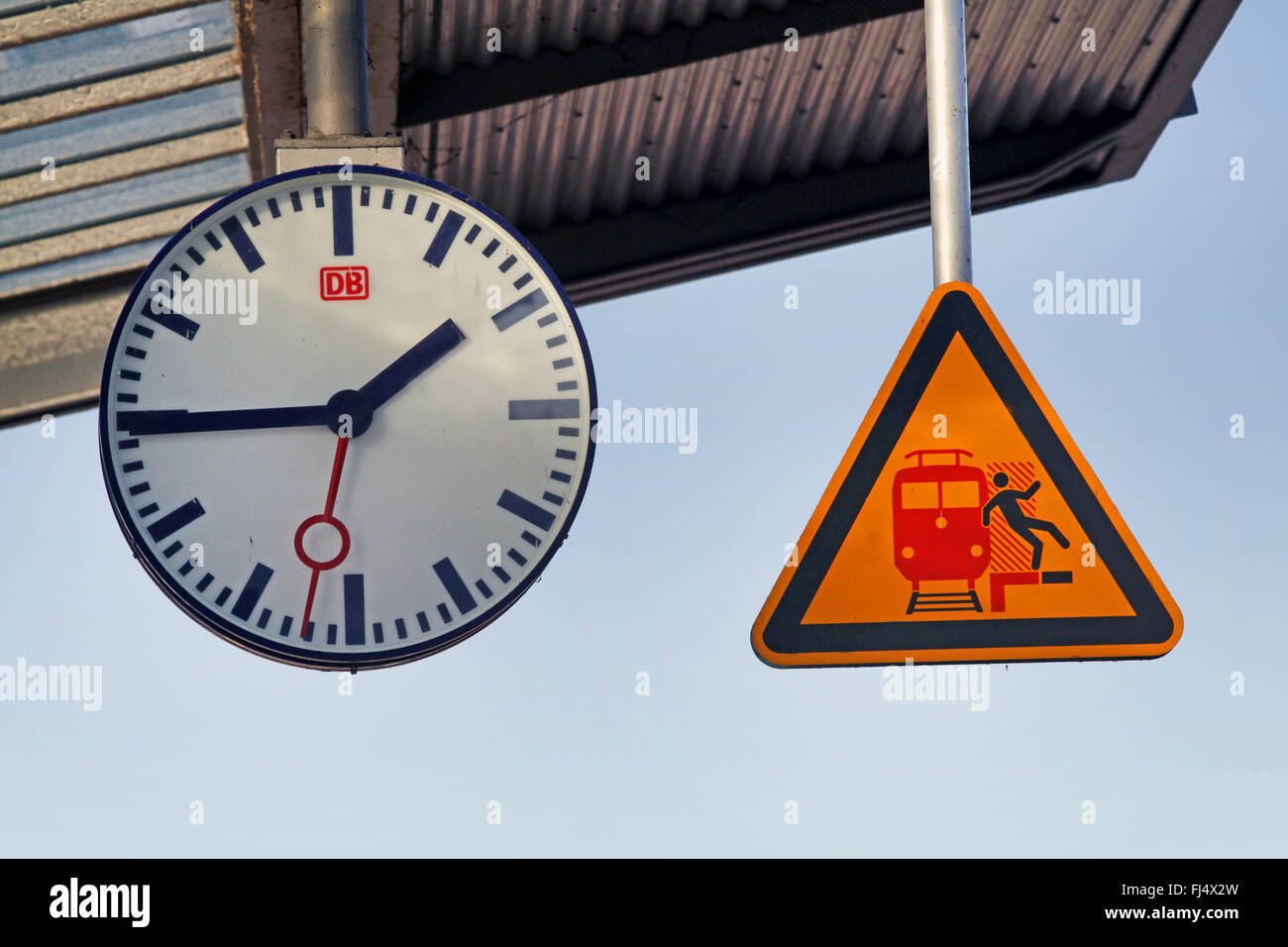 station clock and warning sign at a train station, Germany Stock Photo ...