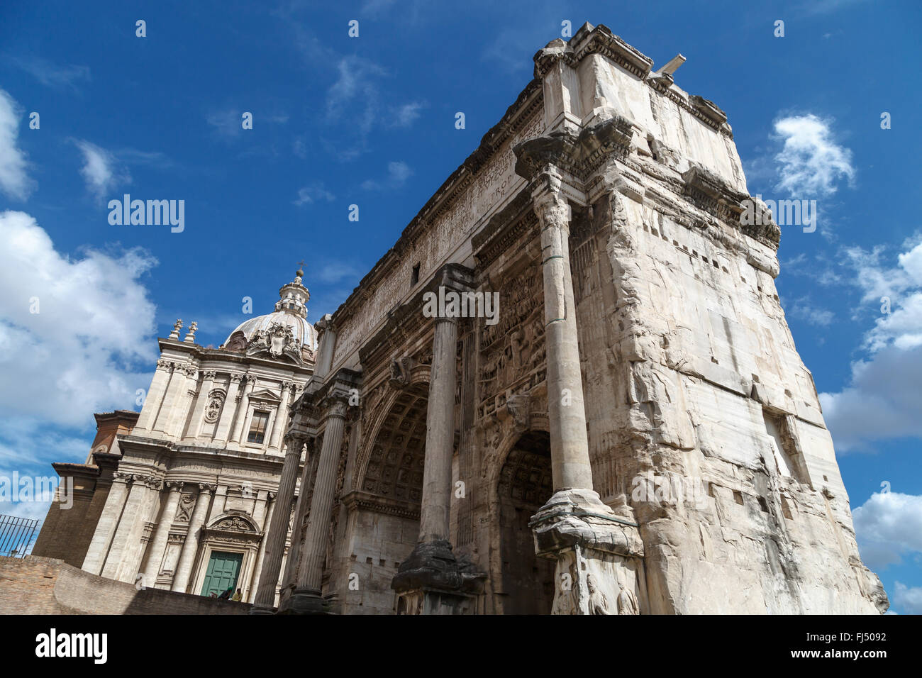 Bottom view of ancient arch with columns at Roman Forum, on cloudy blue ...