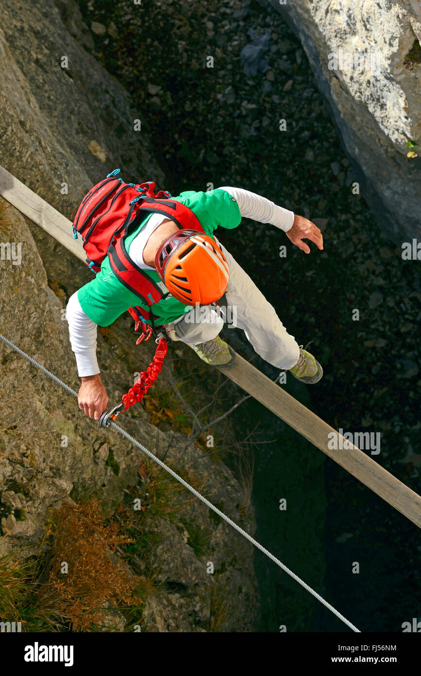 climber crossing a gorge on a small wooden beam, via ferrata Jules ...